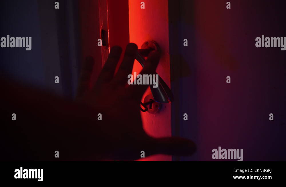 Horror scene with hand of murderer opening slowly door into the room ...