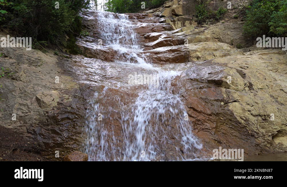 Steps formed on natural rock with flowing river water down, static view ...