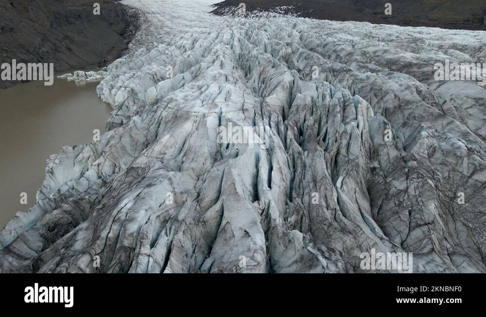 Drone view of ridges of glacier. Icebergs and chunks of ice floating on ...