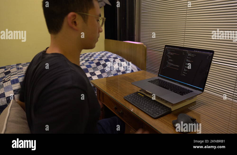 Programmer Sits In Front Of Laptop With Visual Studio Code On Screen ... Programmer Sits In Front Of Laptop With Visual Studio Code On Screen ...