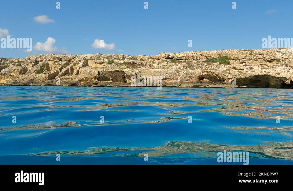 Extreme Low-angle sea-level view from sailing boat of Favignana island ...
