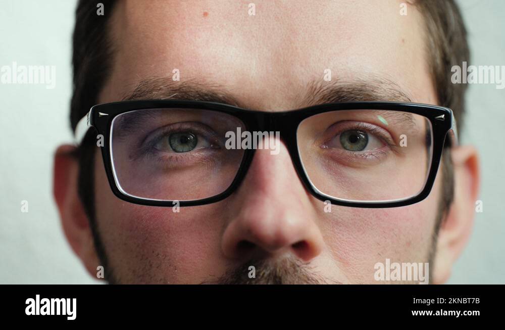 Close up of man's face with glasses. Boy opening and closing his ...