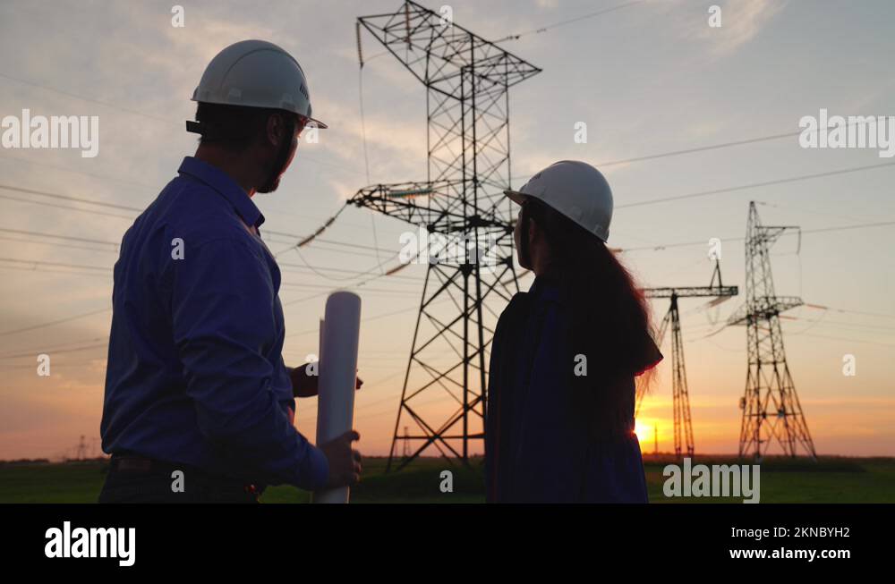 Two construction engineers work together on an electrical transmission ...