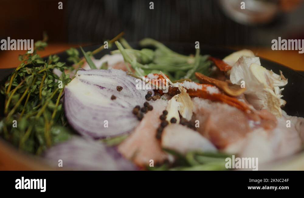 Close on a pot with vegetable soup ingredient. Chef adds spices and ...