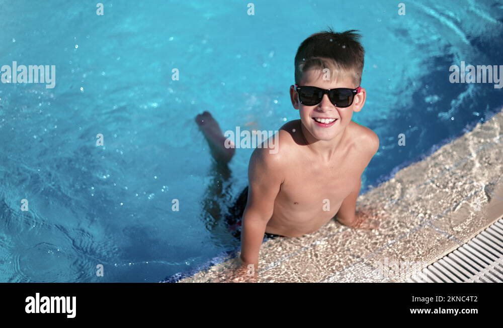 Cheerful child boy tanned skin wearing sunglasses playing legs ...