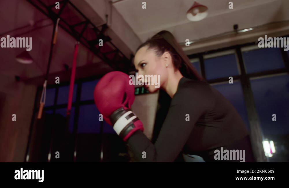 Pretty woman training punching bag in fitness studio. Side view Stock Video Footage - Alamy