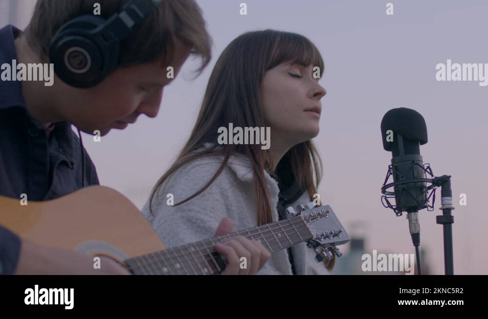 Girl with closed eyes singing into a mic. The inspired female singer ...