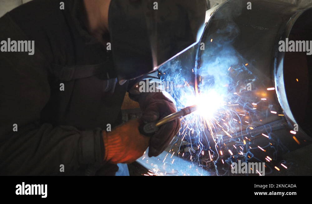 Welder doing joint between two steel details. Man welding metal detail ...