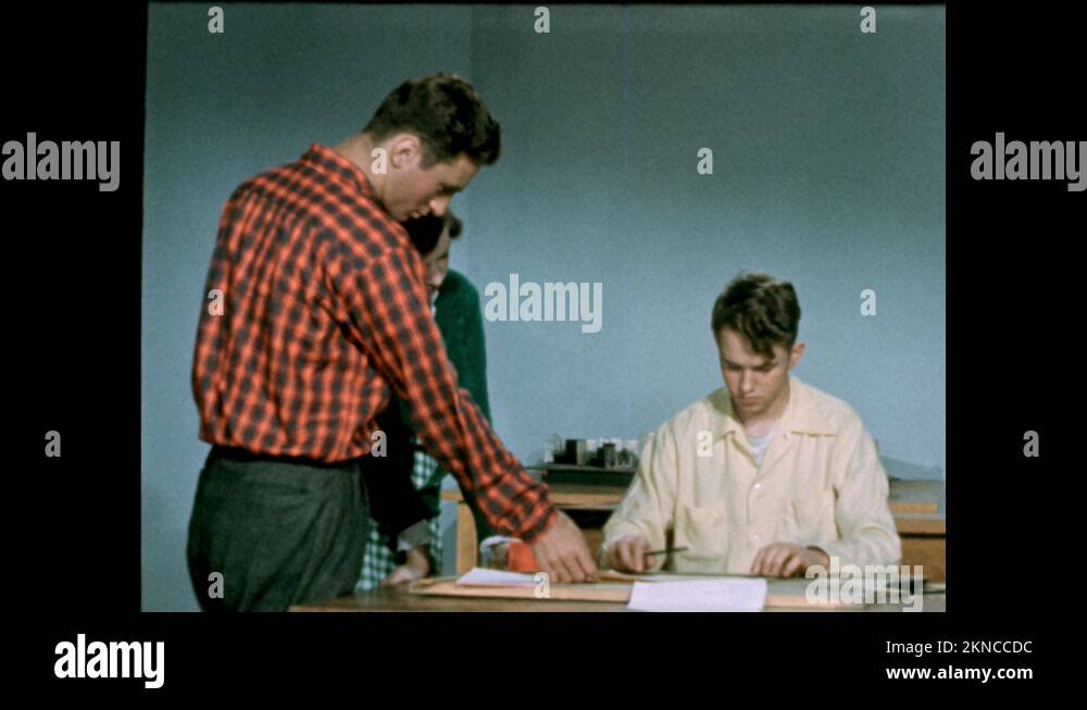 1940s: Boy at desk starts to draw. Standing boy and girl look at plans ...