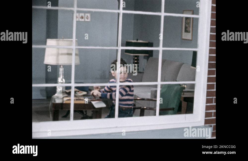 1950s: Hand with clapboard. View through window, boy playing with ...
