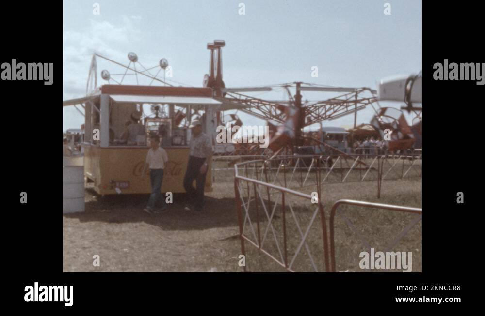 1950s: Rides at the county fair. Film slate. A group of people eating ...