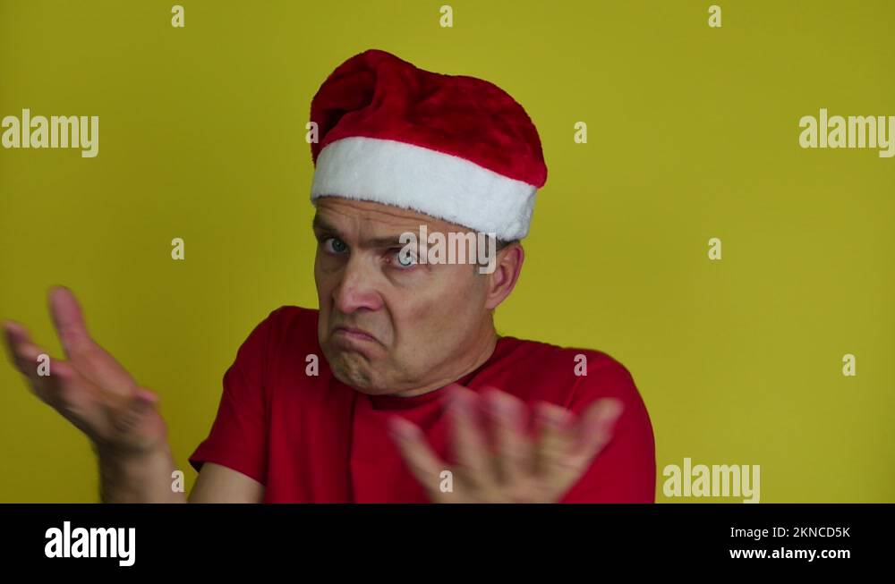 The man in the yellow background gestures with his hands and shakes his ...