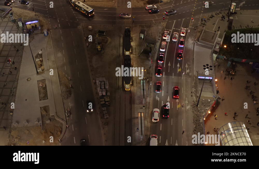 Descending and tilt up footage of vehicles driving through road ...