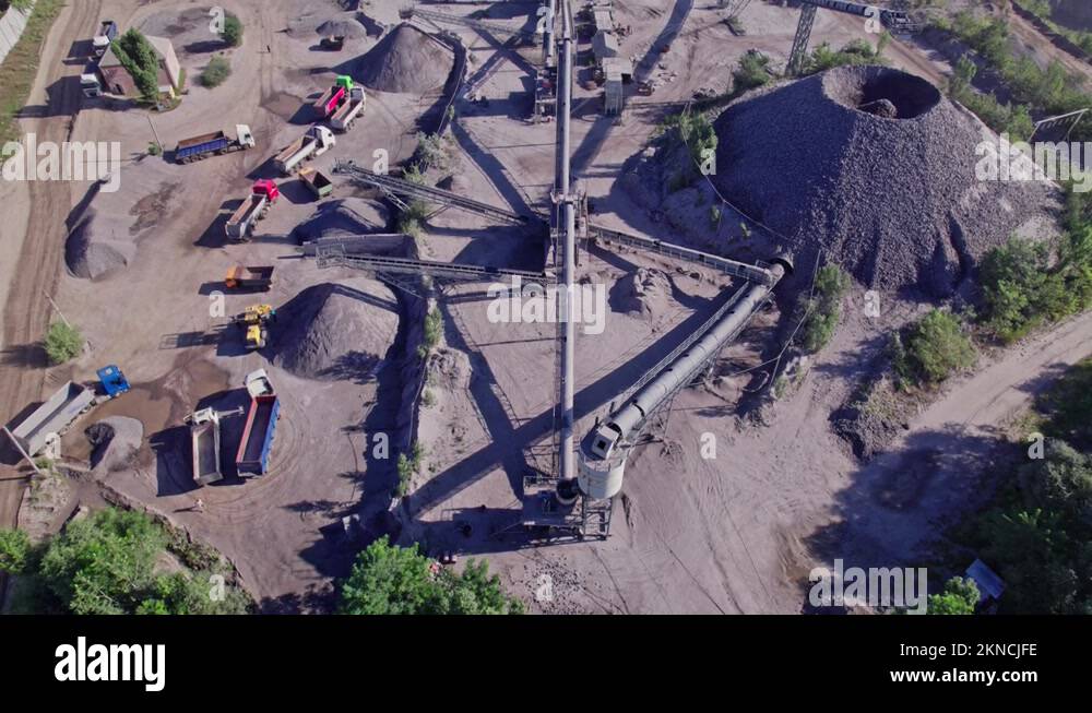 Excavator loading crushed stone into a dump truck in a crushed stone ...