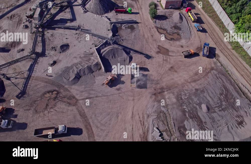 Excavator loading crushed stone into a dump truck in a crushed stone ...