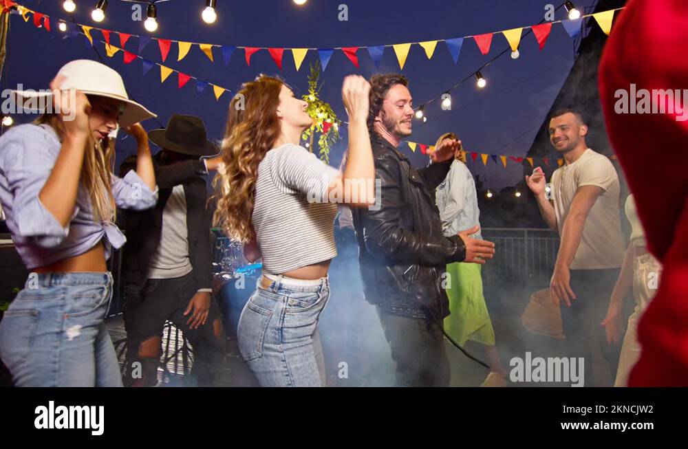 Young caucasian couple dancing and laughing on a rooftop party. Fun ...