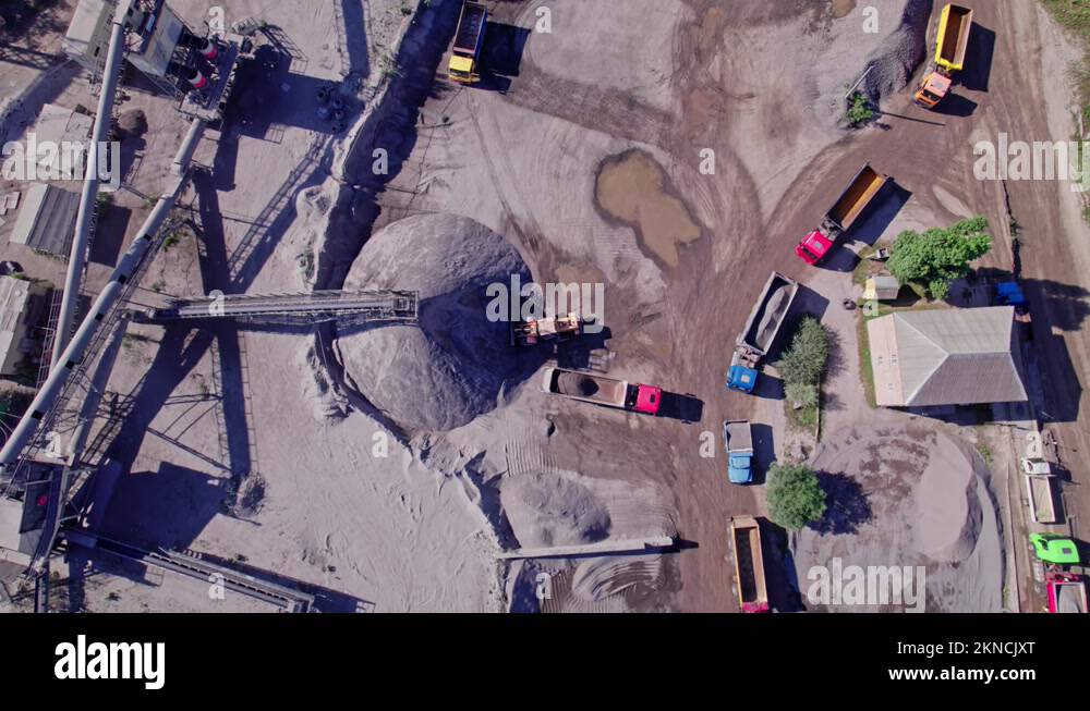 Excavator loading crushed stone into a dump truck in a crushed stone ...