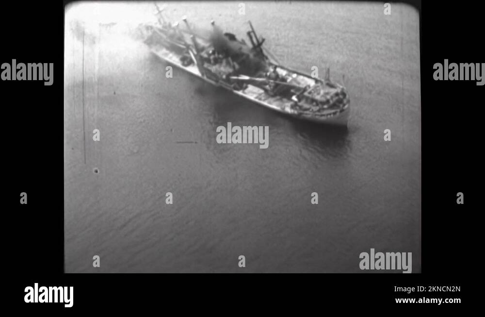 1950s: Large tanker ship sinks in ocean. Flying over sinking ship. Fire ...