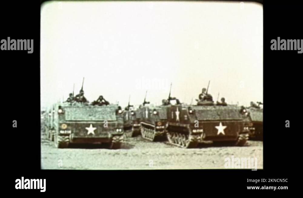 1960s: Radar dish spins. Men mount tanks at military base. Civilians ...