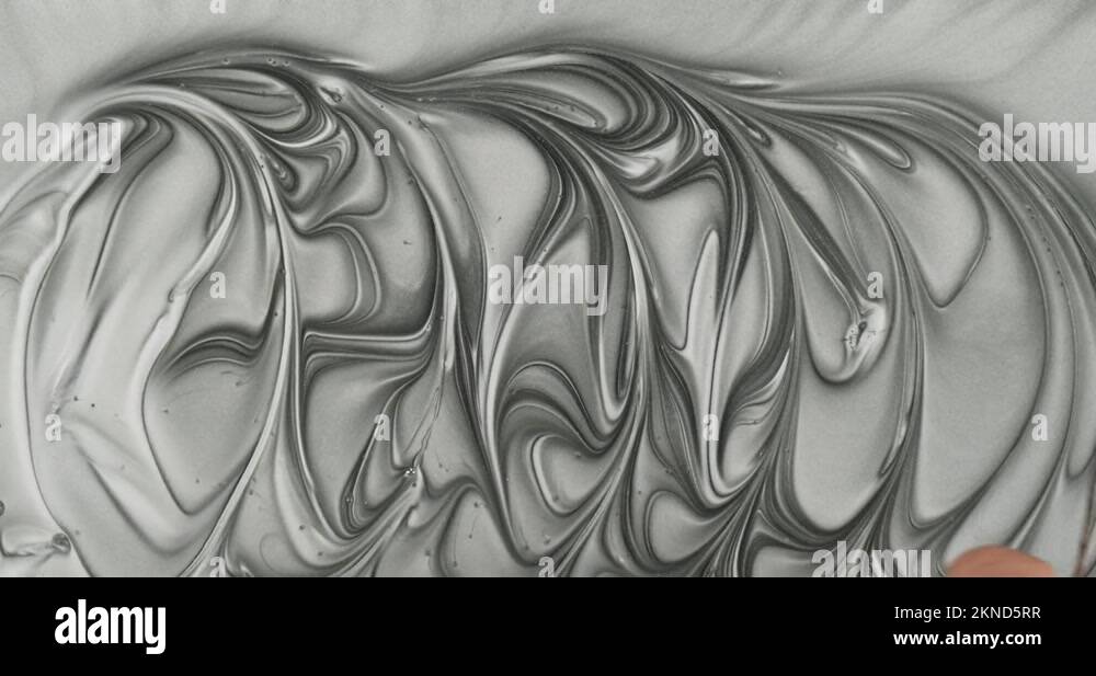 Drawing with a stick on liquid silver paint. Lines in the paint. Top ...