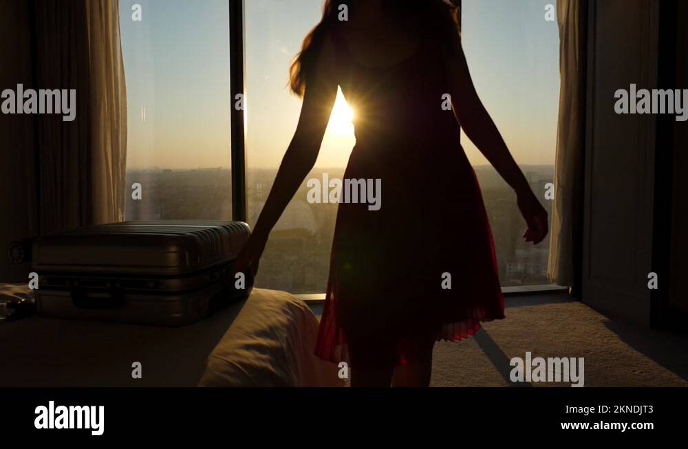 Woman throws goodbye look at city, picks up her suitcase from bed and ...