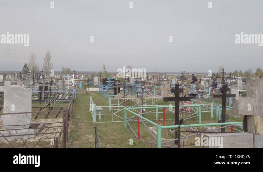 Few people in the Russian cemetery among the crosses of tombstones and ...