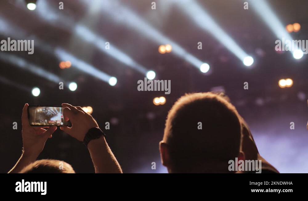 People recording video and showing devil horns gesture at rock concert ...