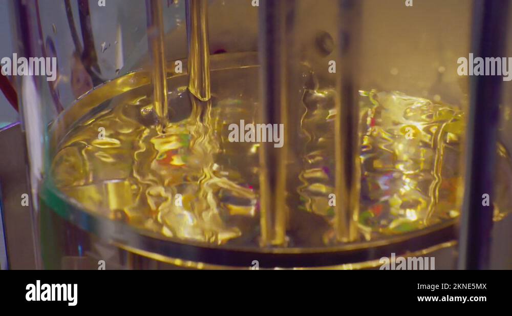 a beautifully illuminated liquid molten metal is stirred in a ...