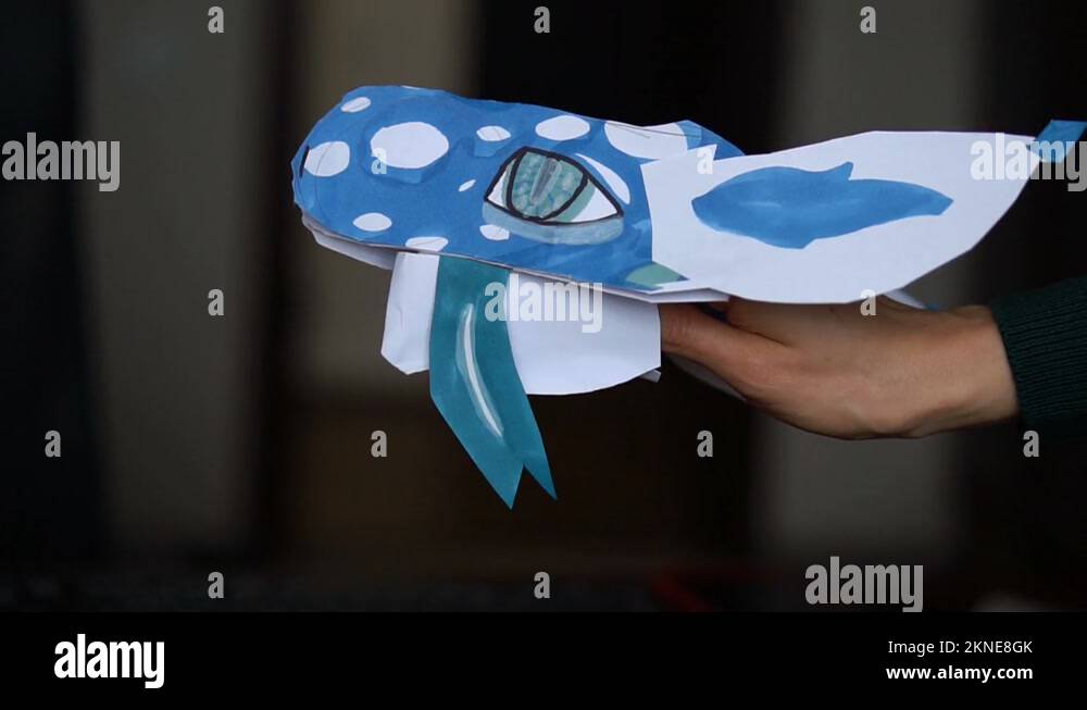 Blue origami dragon with long tongue in child hands, paper dragons ...