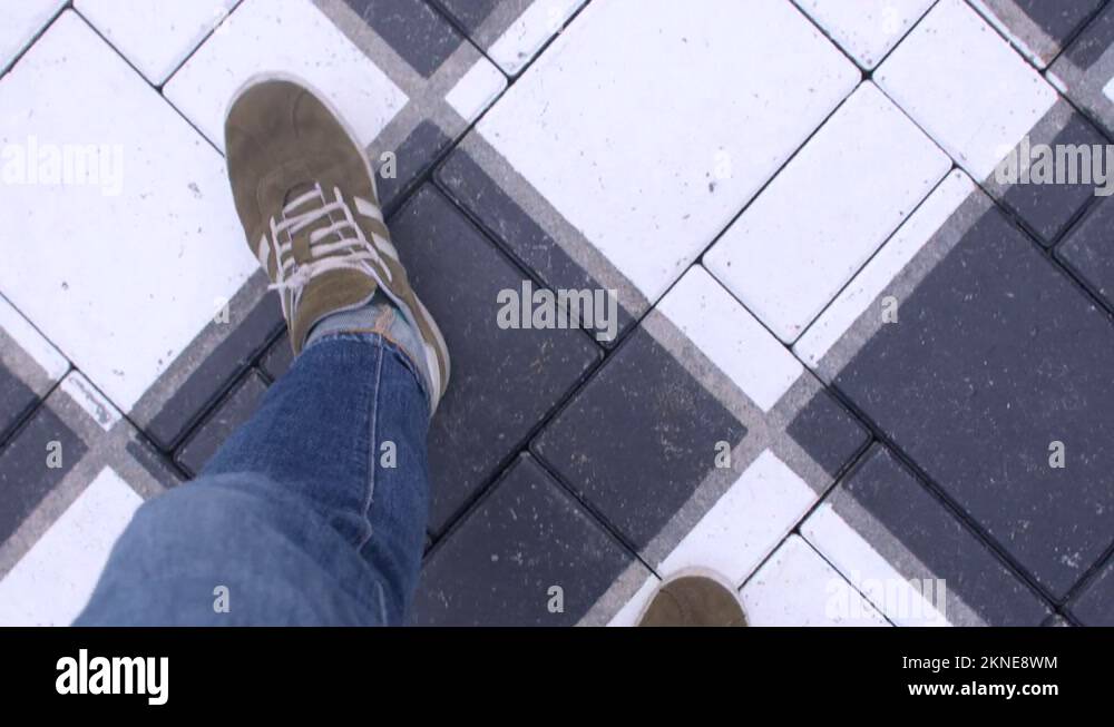 Human feet trample on the black and white squares of the chess field ...