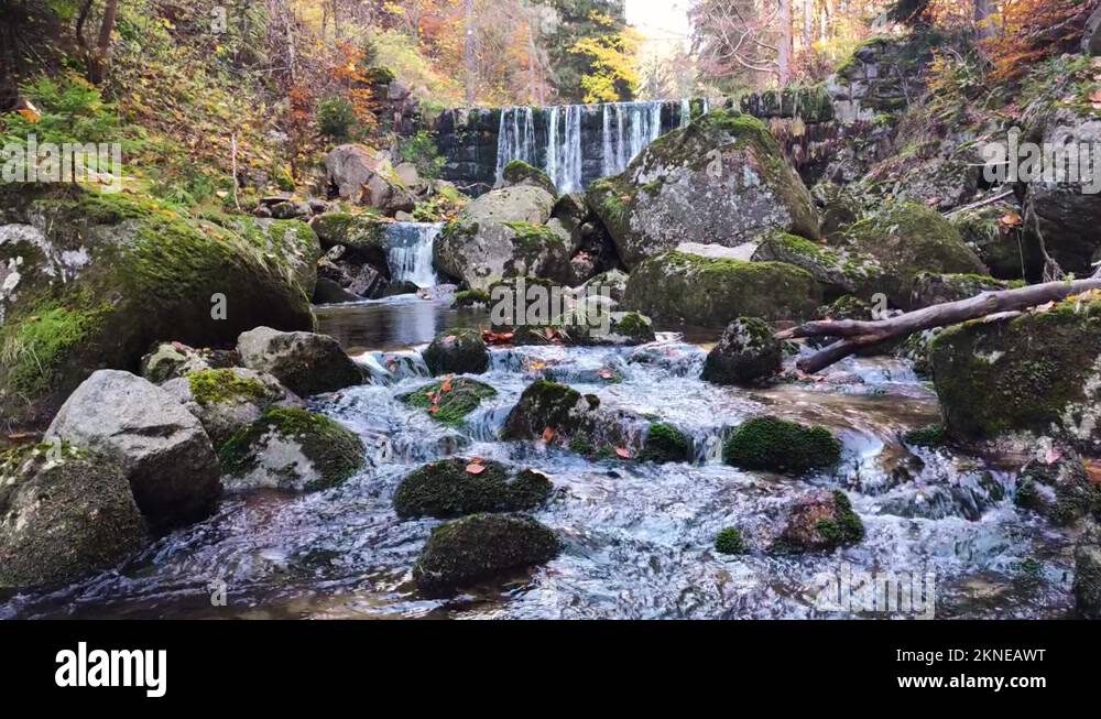 flowing river full of big mossy boulders and a stone weir, jib up Stock ...