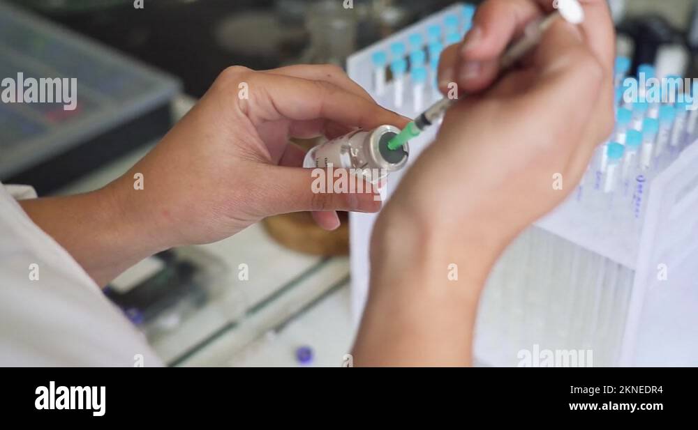 Female doctor drawing vaccine from vial into syringe for injection ...