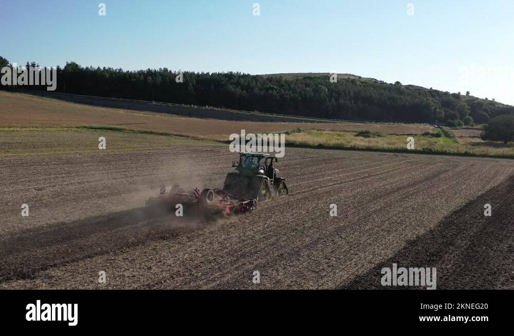 Tractor Plowing Land on Dry Dusty Farming Field on a Sunny Morning ...