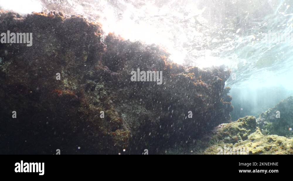 choppy water wavy sea underwater wave hit rocks and makes foam on the ...