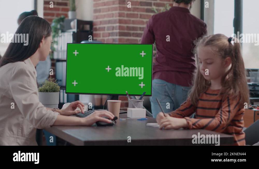 Single mom using computer with horizontal green screen, having little ...