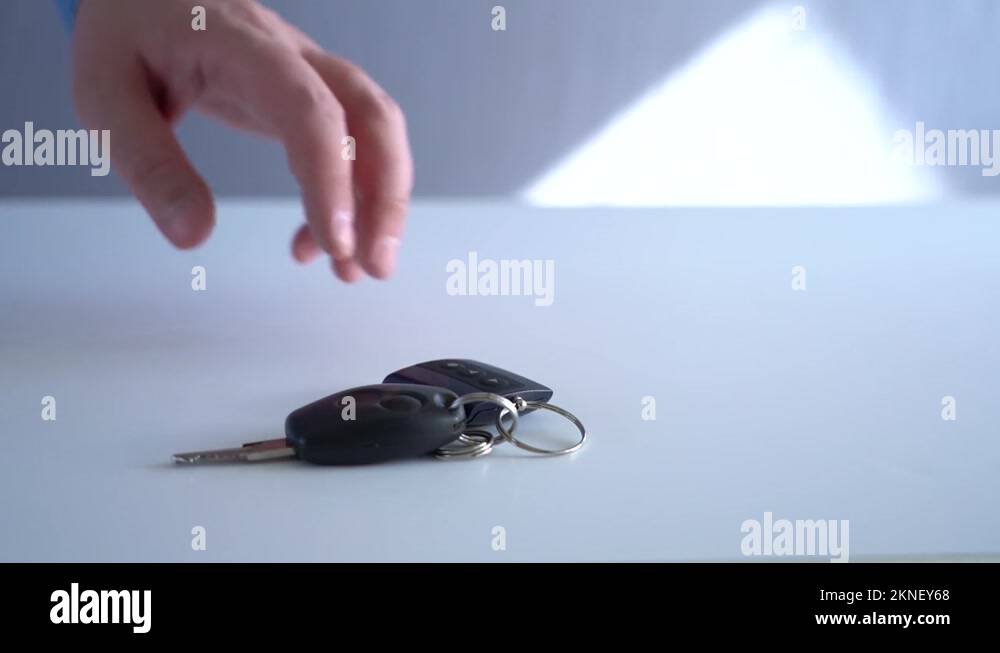 Take the car keys from the table. Male hand takes car keys with remote ...