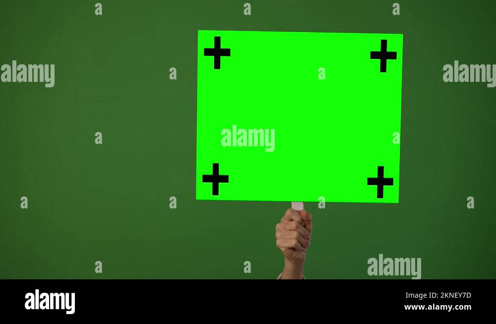 Arm holding a green screen sign with tracking points on a chroma key ...