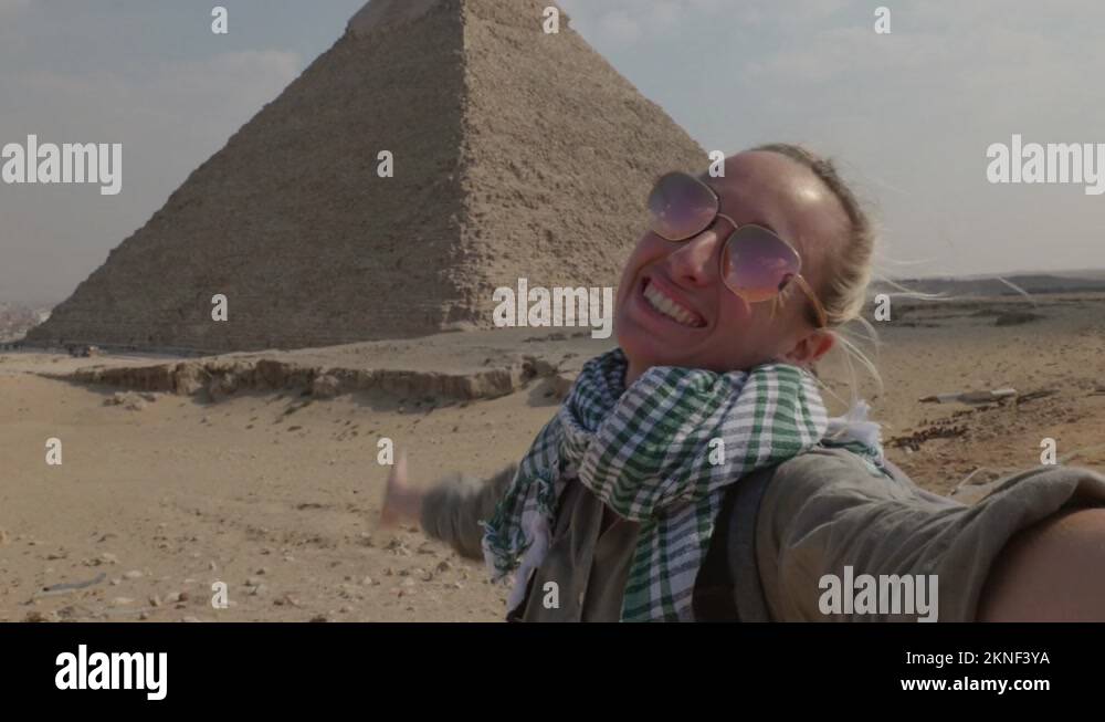 Young woman sightseeing the Great Pyramids of Giza takes cool selfies ...