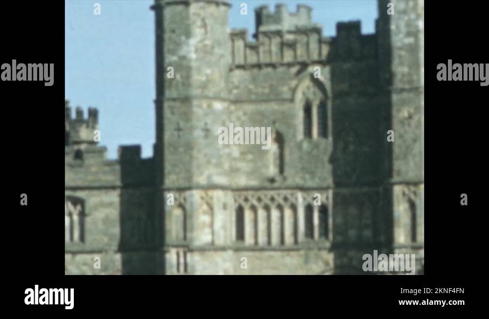1950s: Castle facade. Hand holding chalkboard. People in robes walking ...