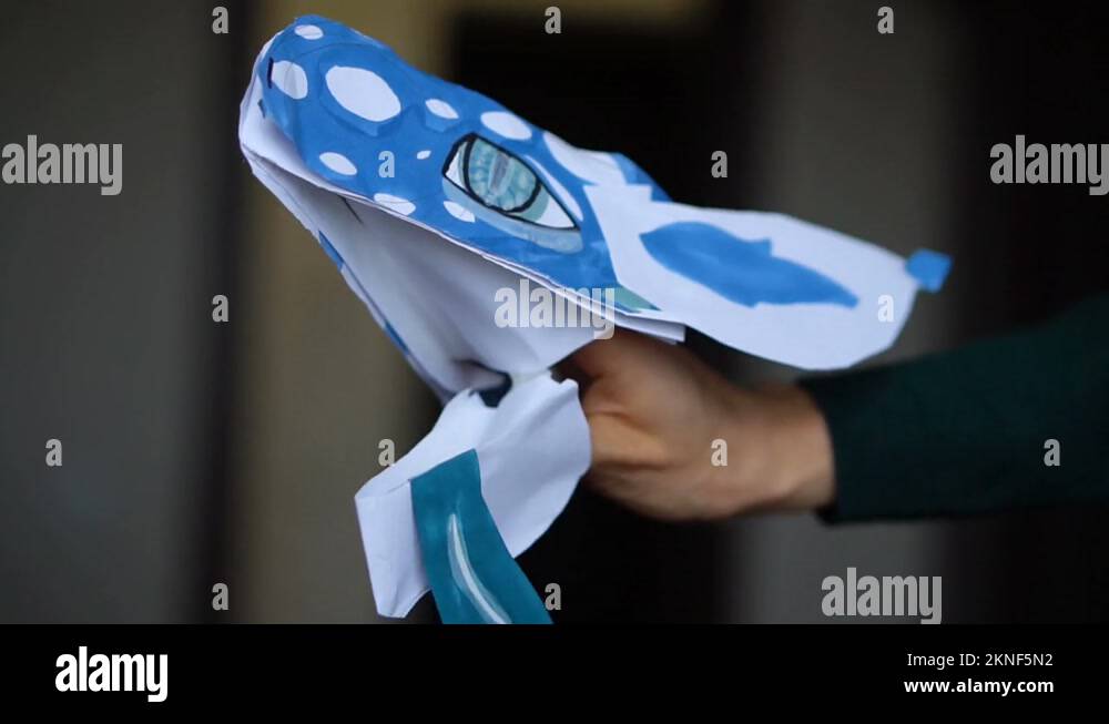 Blue origami dragon with long tongue in child hands, paper dragons ...