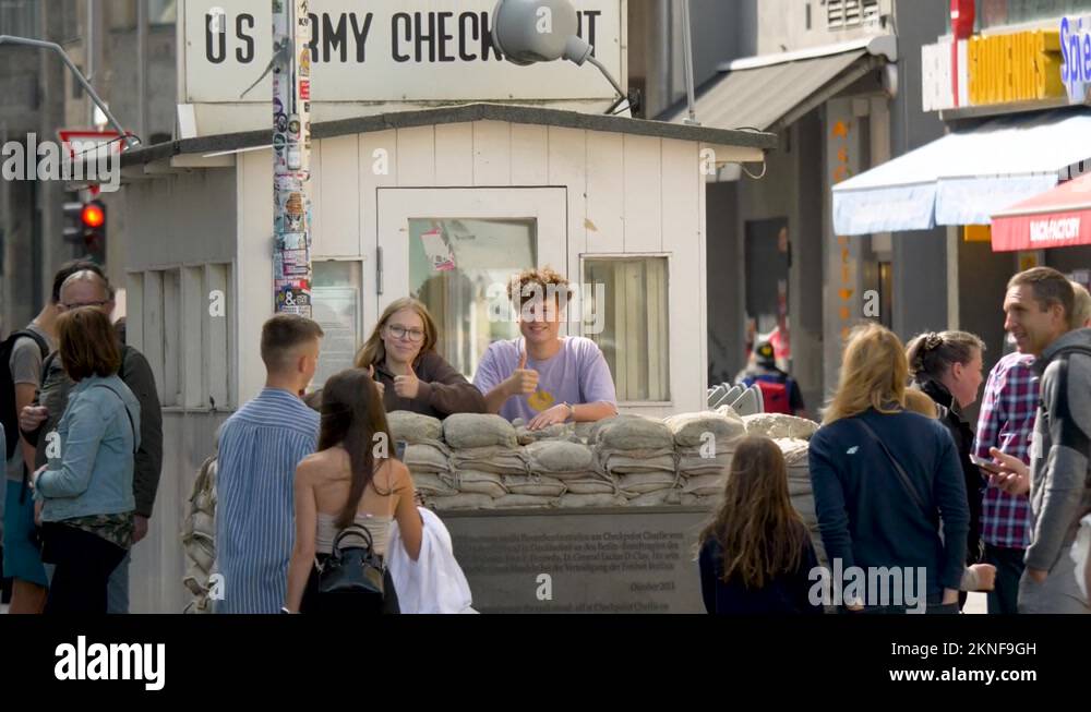Two happy teens taking a picture in front of the Checkpoint Charlie ...