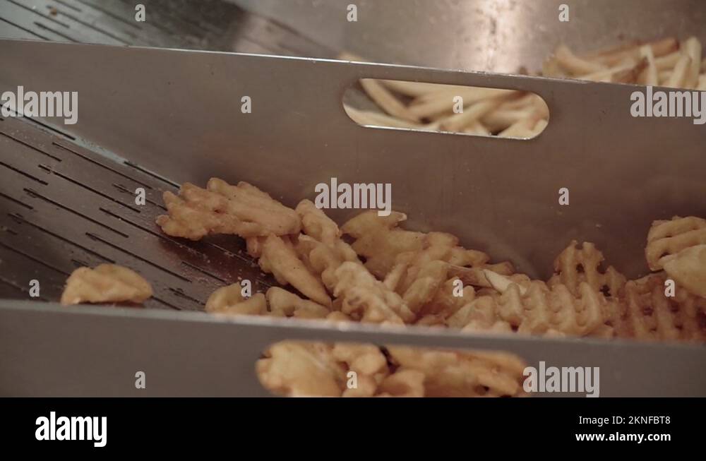 Fast Food, Cooking Fries Potato. A human takes french fries with tongs ...