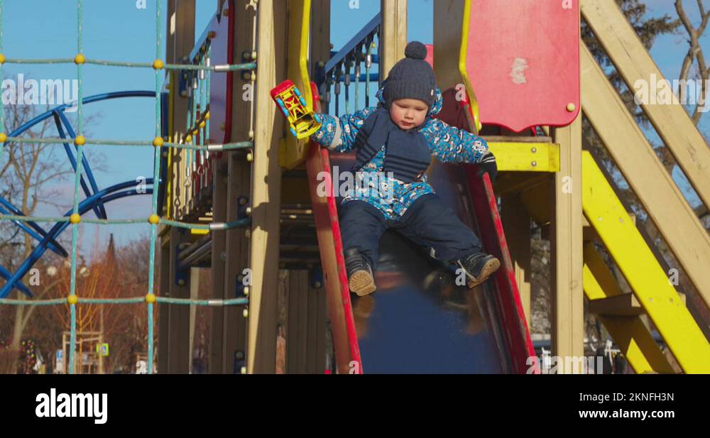 Child on Walk in the Park. Baby on Playground going down a Slide in ...