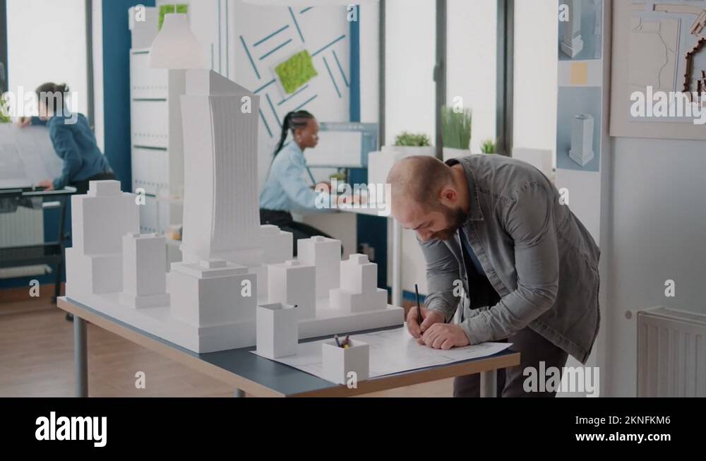 Man Architect Taking Notes On Blueprints Plan To Design Building Structure And Stock Video