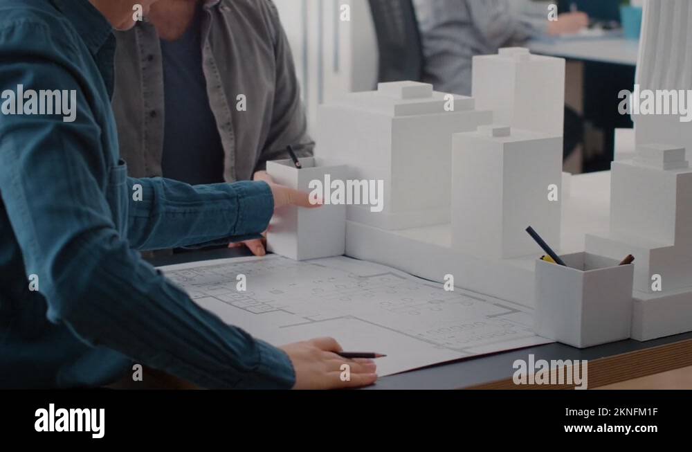 Close Up Of Colleagues Analyzing Blueprints Plan And Building Model To Design Stock Video
