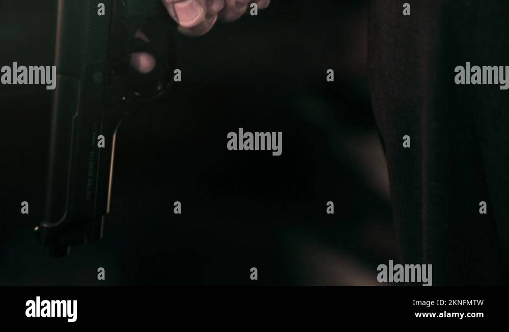 Close up on hands of secret agent man in suit holding a pistol, pan up ...