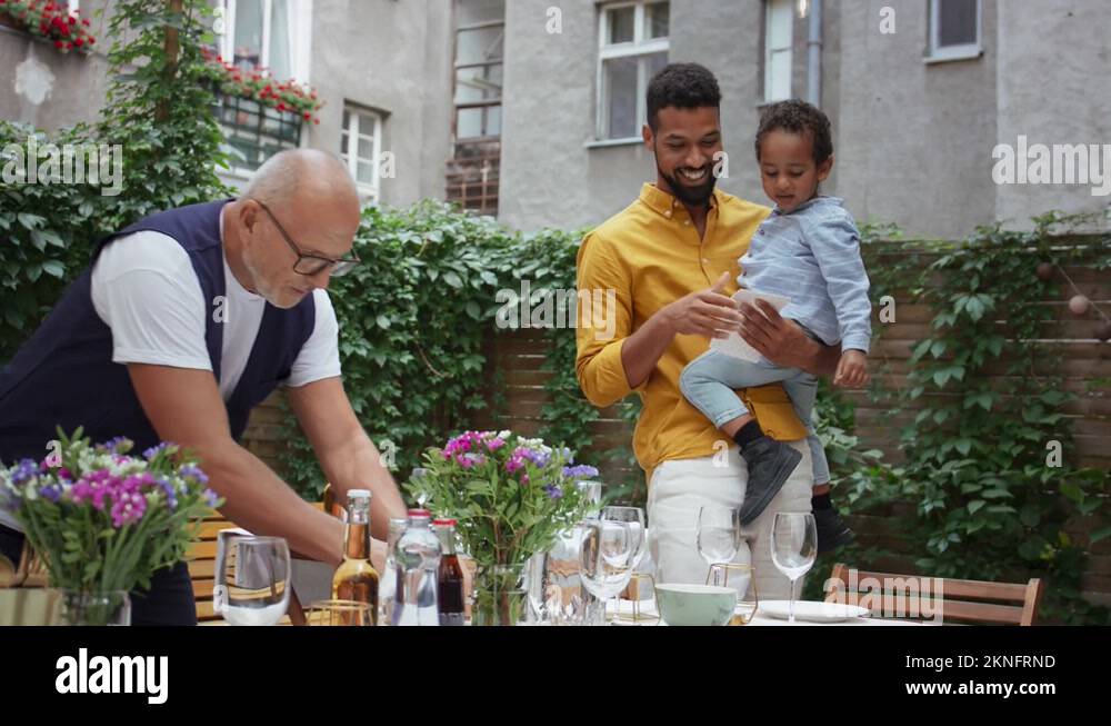 Father with small son and his grandparents setting table for family ...