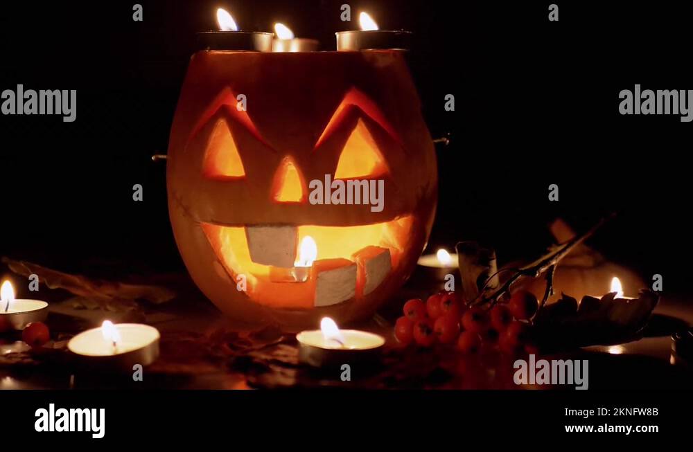 Pumpkin with a Scary Jack-o-Lantern Face, Candles Burning in Dark Room ... Pumpkin with a Scary Jack-o-Lantern Face, Candles Burning in Dark Room ...