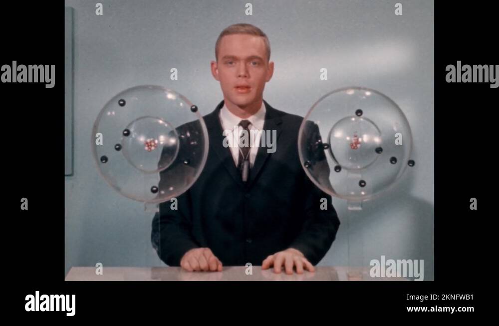 1960s: Man talking. Man standing with electron models. Man pointing to ...