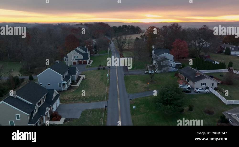 Reverse aerial dolly reveal of new homes lining road in rural America ...